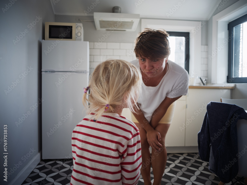 Little girl begging for cookies in the kitchen while her mother gently ...