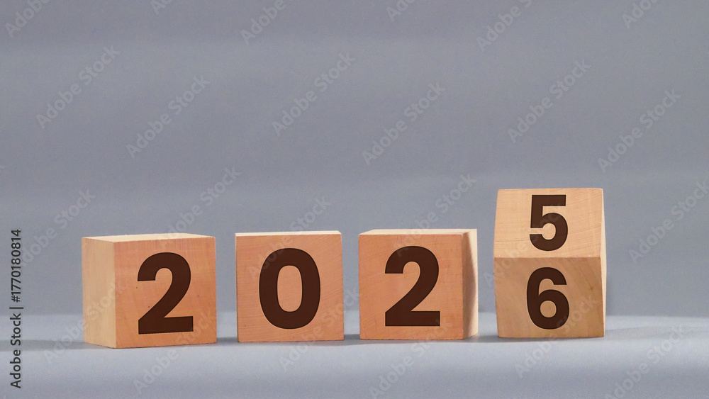 Stock-Foto „Wooden cube flipping from 2025 to 2026 on gray background ...