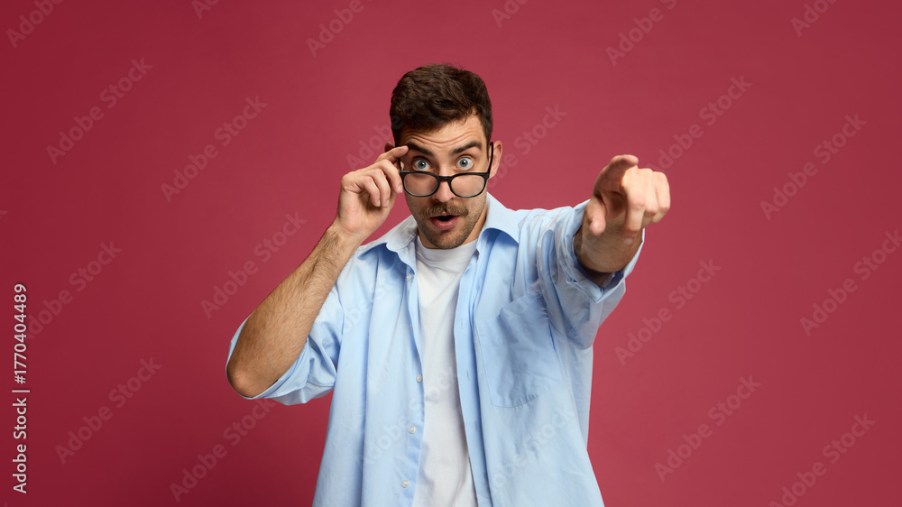 Surprised man pointing finger forward with amused facial expression ...