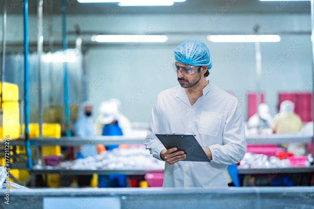 A manager oversees the supply chain in a food processing warehouse. He ...