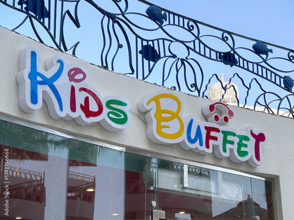 Fotografie Colorful Kids Buffet restaurant sign on a building facade in ...