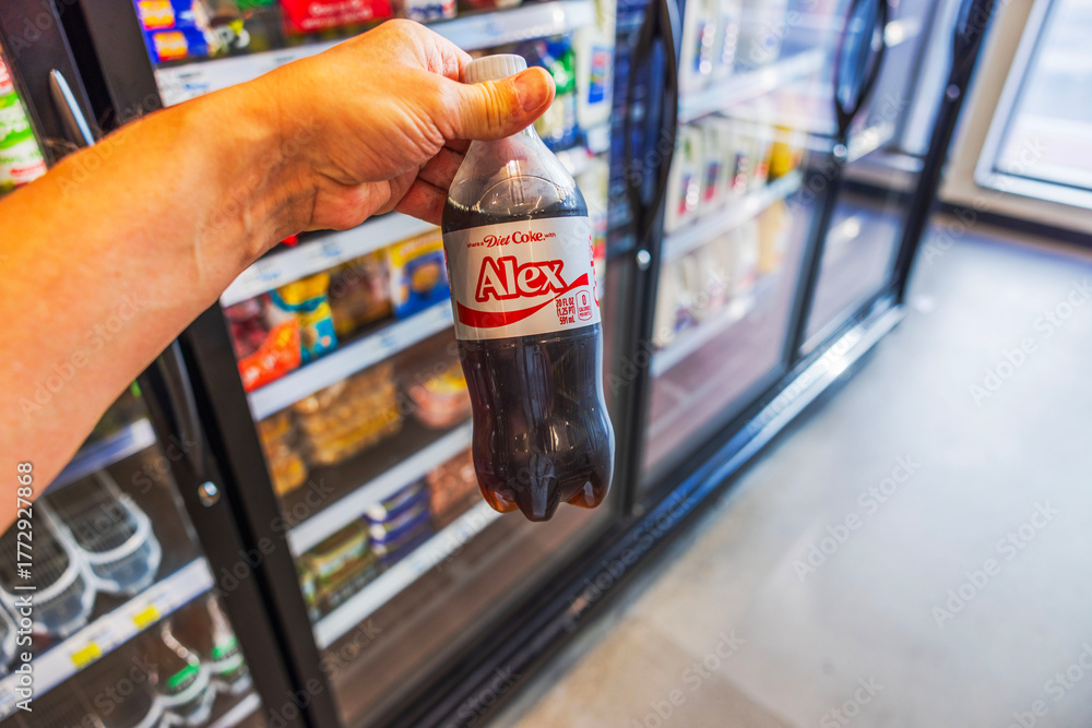 Hand holding Diet Coke bottle with name Alex in front of refrigerator ...
