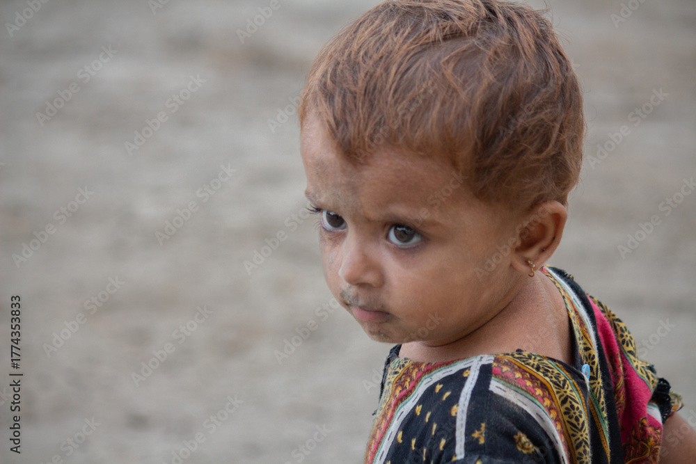 Poor Pakistani village girl looking back with serious face showing ...