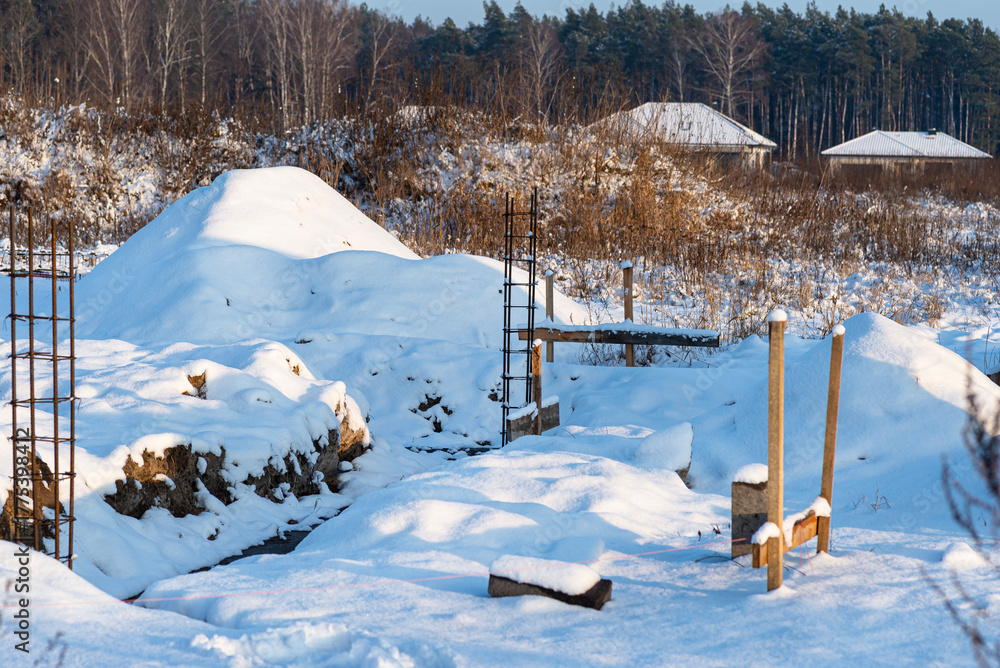 Foundation footings poured in a trench made of sandy soil, visible ...