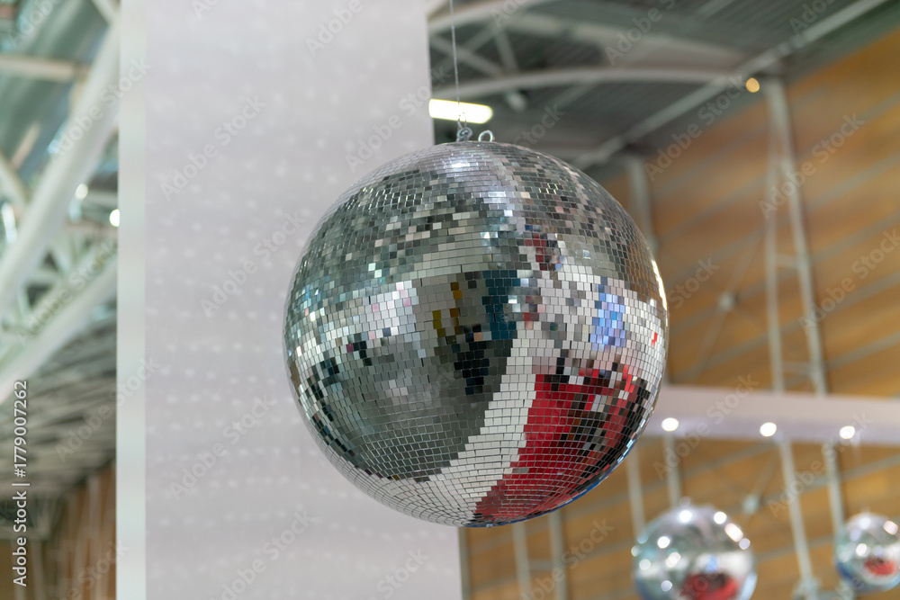 Mirror ball suspended in a nightclub with light shows, a vibrant ...
