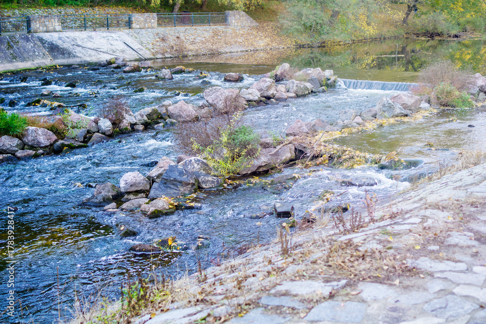 shallow river water flowing rapidly over a series of rocks and small ...