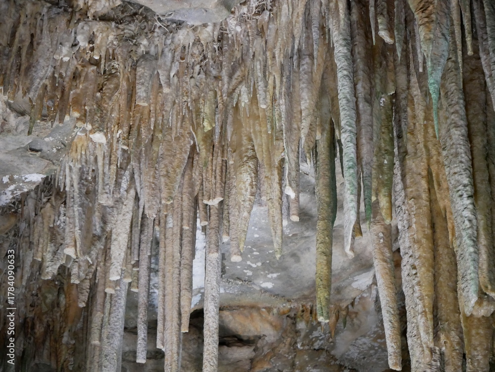 Stock-Foto „Stalactites and stalagmites illuminated inside a limestone ...