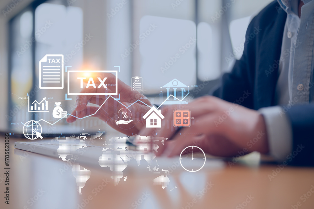 Businessman typing on computer keyboard with tax document icon overlay ...