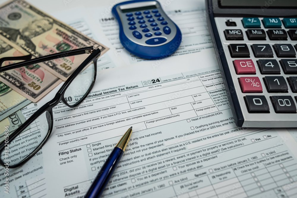US dollar bills and form 1040 with glasses and calculator ready for ...