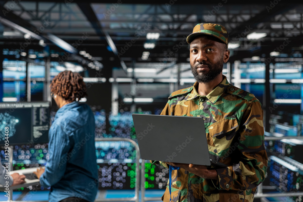 Black military engineer in data center uses laptop for AI systems ...
