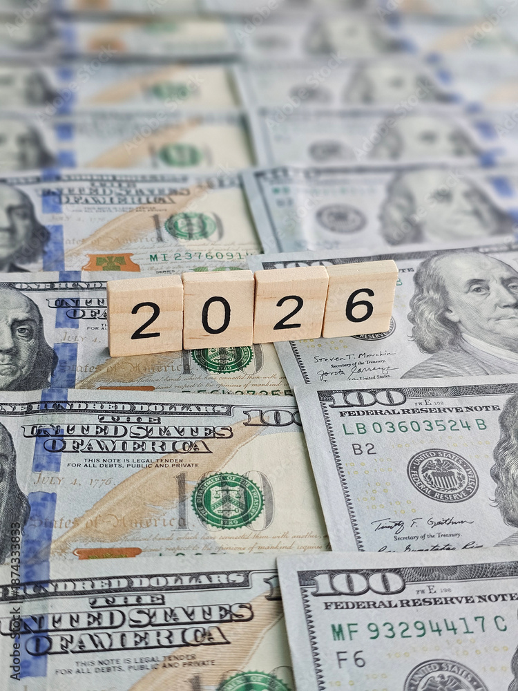 Money arranged with wooden blocks showing the year 2026 Stock Photo ...