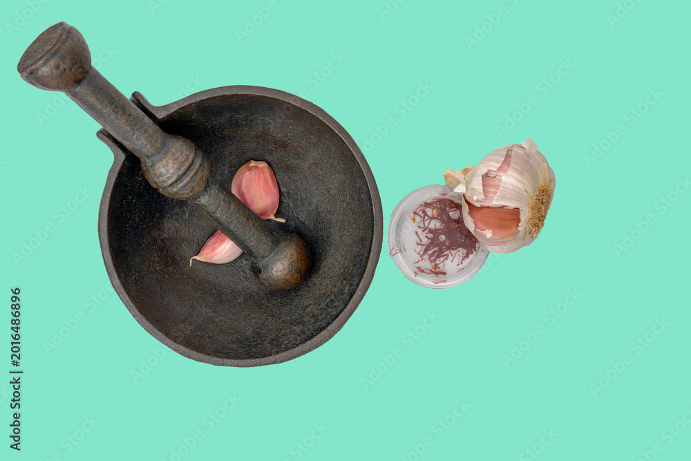 Cast iron mortar and pestle preparing garlic cloves and spices for ...