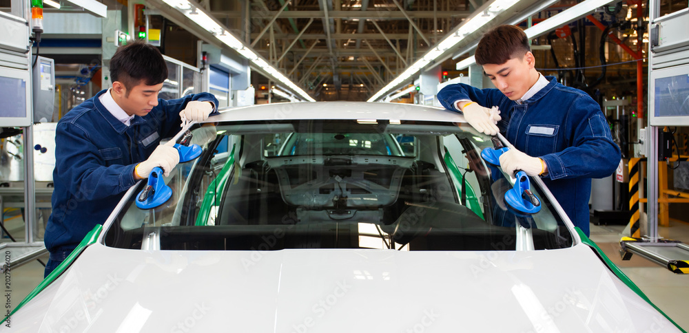 Asian workers at a car factory are installing car windows. Stock Photo ...