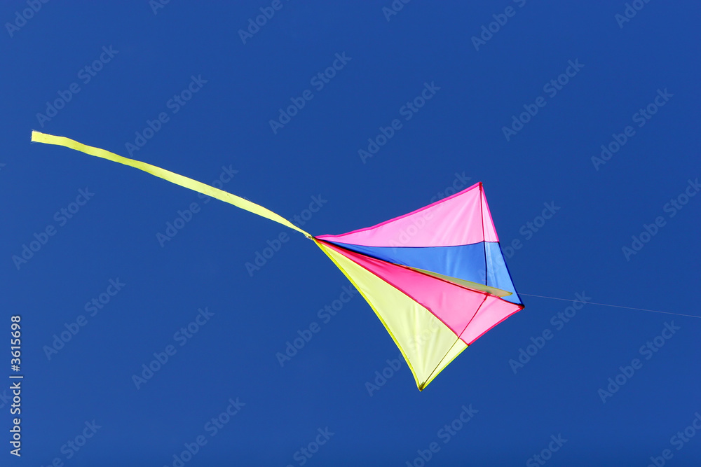 kite flying against a blue sky, bright colors and streaming tail Stock ...