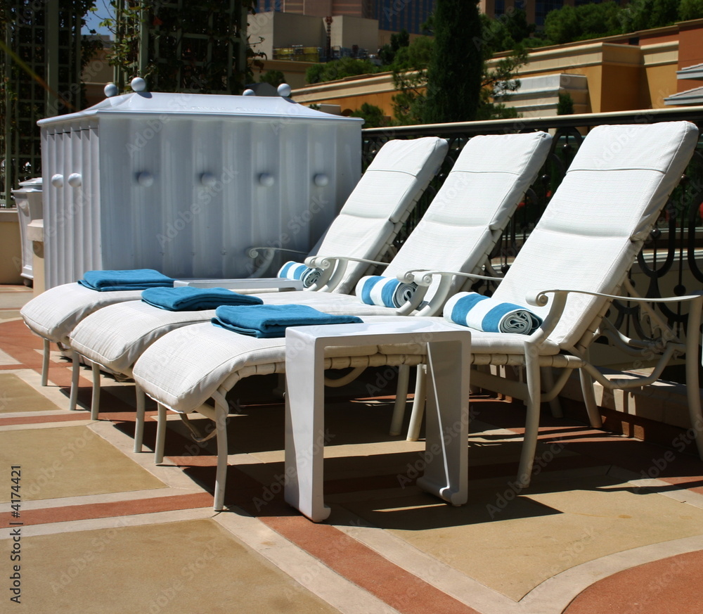 Three White Lounge Chairs Sitting Empty by the Swimming Pool Stock ...