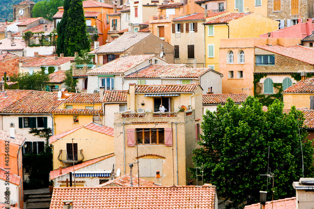 Maisons à toits rouges devant une colline verte. Stock Photo | Adobe Stock