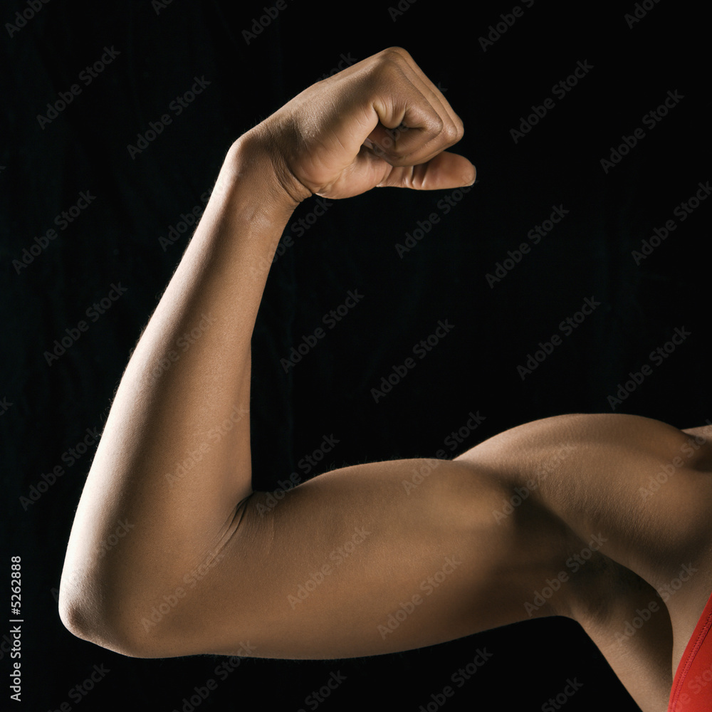 Strong female bicep flexing. Stock Photo | Adobe Stock