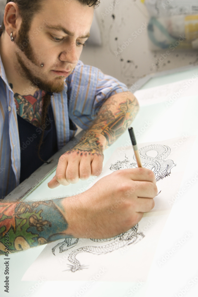Man drawing tattoo. Stock Photo | Adobe Stock