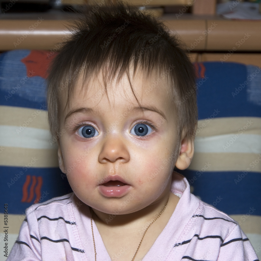 Baby schaut neugierig mit grossen blauen Augen Stock-Foto | Adobe Stock