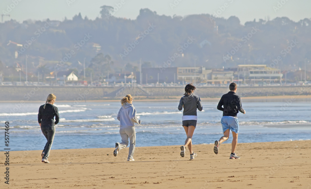 Jovenes corriendo por la playa Stock Photo | Adobe Stock