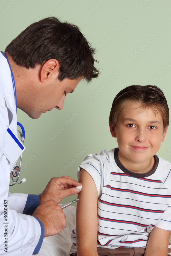 A doctor gives a child a vaccine or flu shot in the arm. Stock Photo ...
