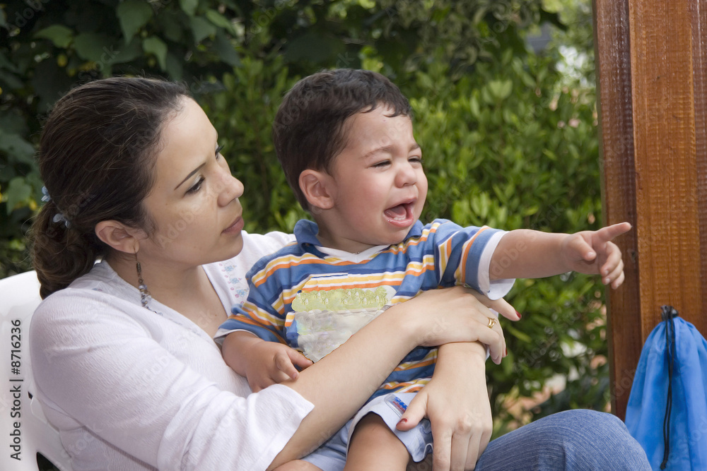 Little boy crying with his mother and pointing with his finger Stock ...