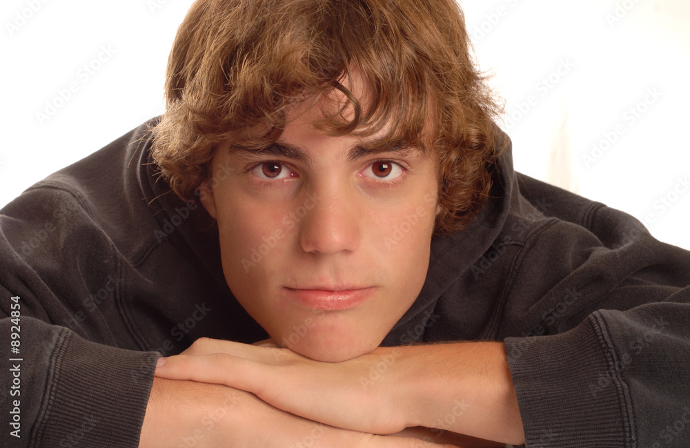 attractive young teenage boy with chin resting on hands Stock Photo ...