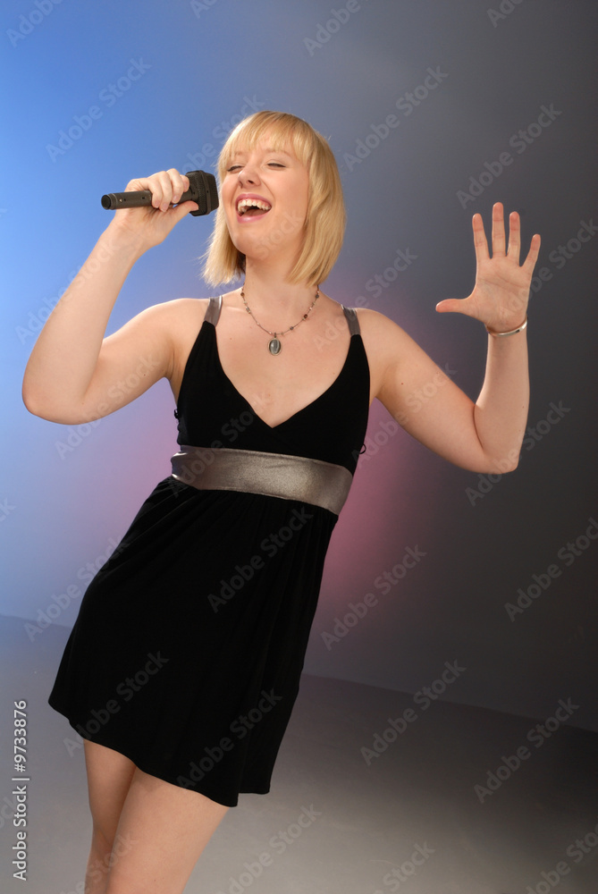 cute blond girl singing with microphone on stage Stock Photo | Adobe Stock