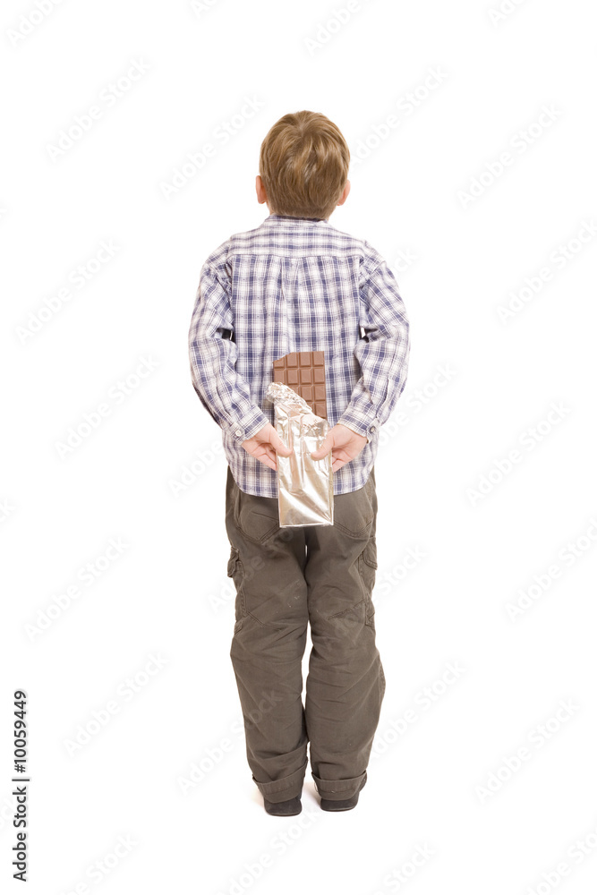 Poster Little boy, hiding a large chocolate bar (isolated on white ...