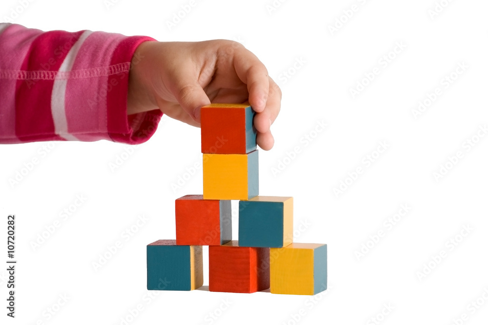 Child hand building a tower of colored blocks Stock Photo | Adobe Stock