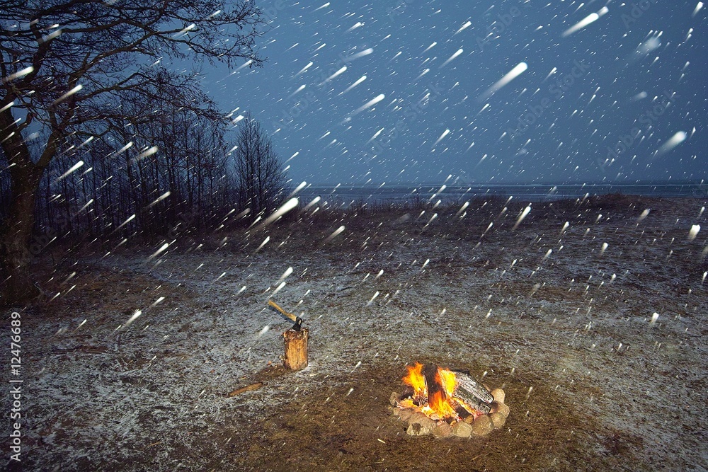 Campfire under falling snow Stock Photo | Adobe Stock