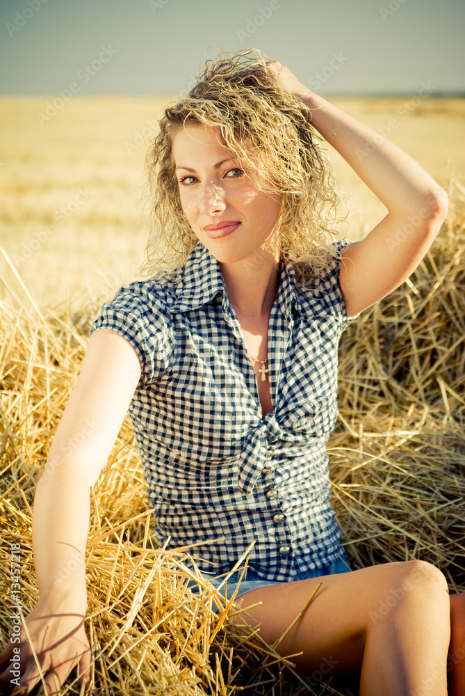 Beautiful country girl sitting on the haystack Stock Photo | Adobe Stock