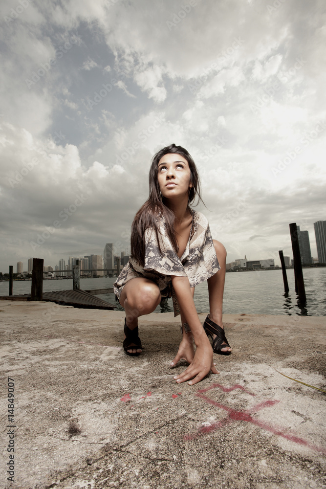 Woman squatting in an outdoor scene Stock Photo | Adobe Stock