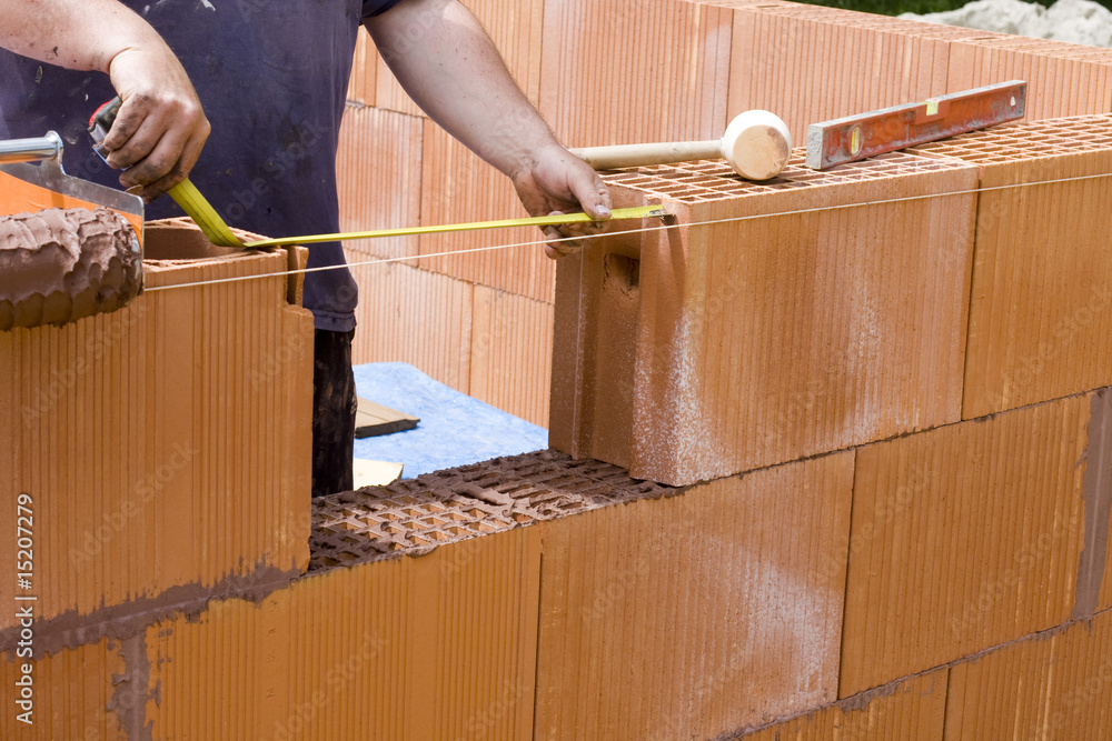 mason made a wall with red bricks Stock Photo | Adobe Stock