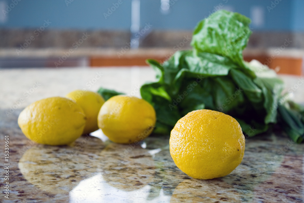 Lemons and salad leaves on a kitchen countertop Stock Photo | Adobe Stock