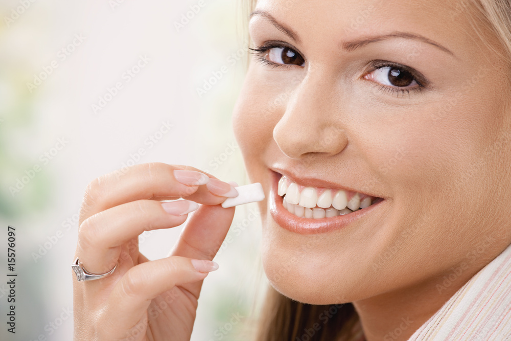 Beautiful woman eating chewing gum Stock Photo | Adobe Stock