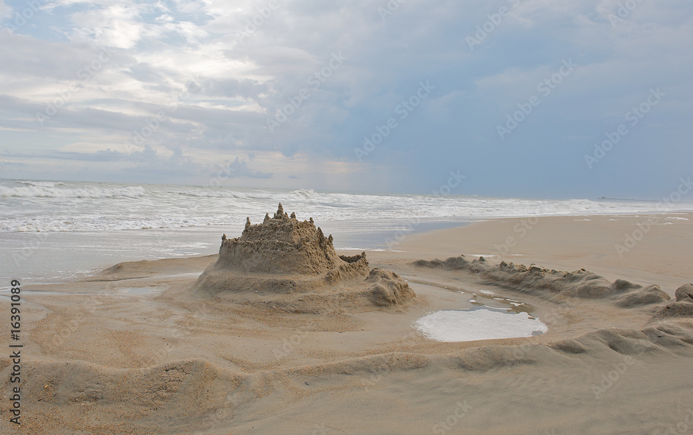 Sand castle built on the beach with moat surrounding it. Stock Photo ...