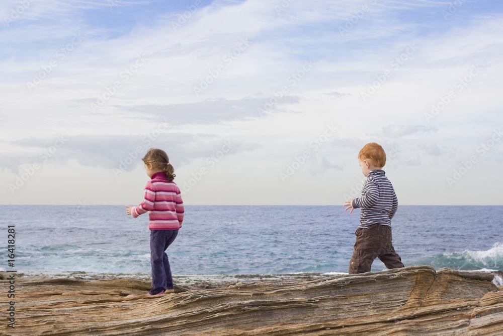 Kids walking on beach rocks Stock Photo | Adobe Stock