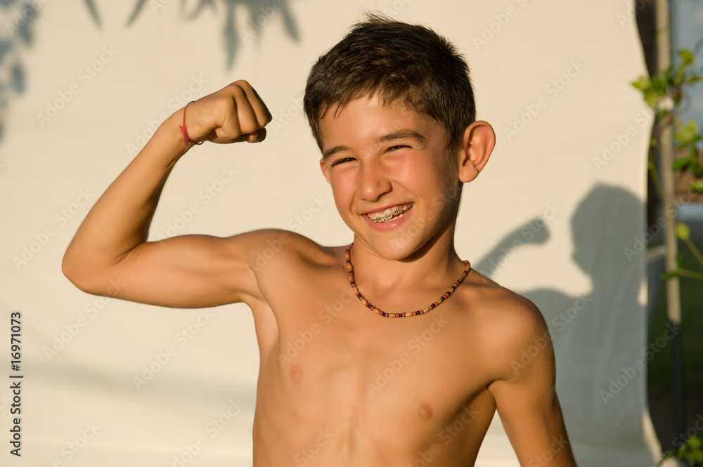 Child that shows the muscles of the arm Stock Photo | Adobe Stock