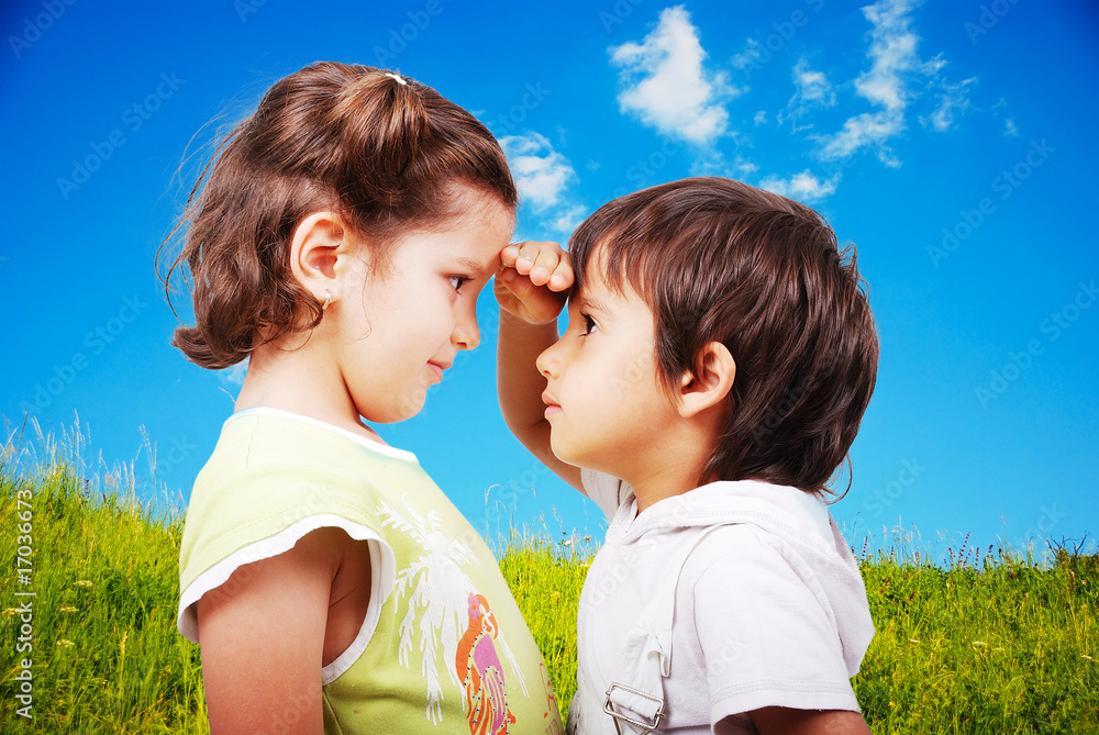 Two cute children, male and female, comparing their height Stock Photo ...
