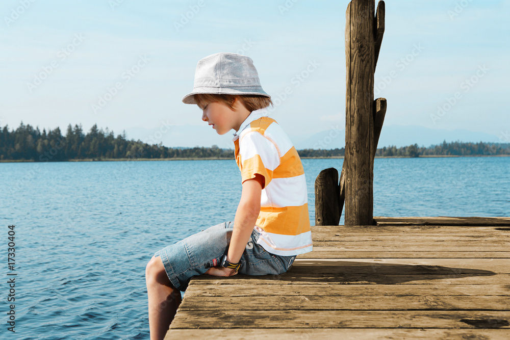 Junge sitzend am Steg Stock Photo | Adobe Stock