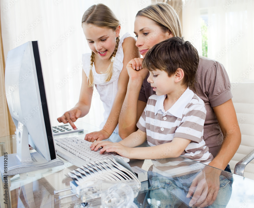 Attentive mother teaching her children how to use a computer Stock ...