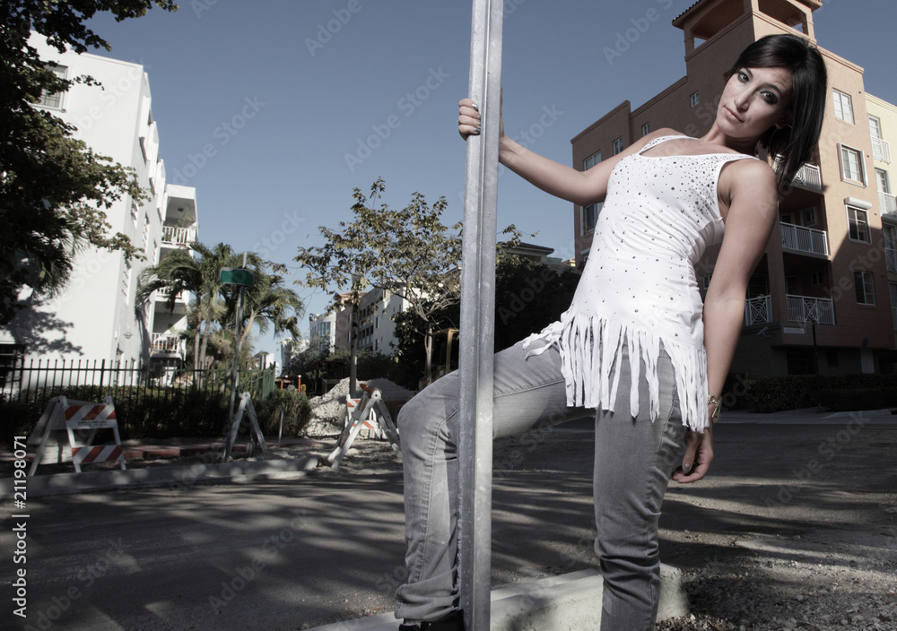 Woman hanging from a pole in the city Stock Photo | Adobe Stock
