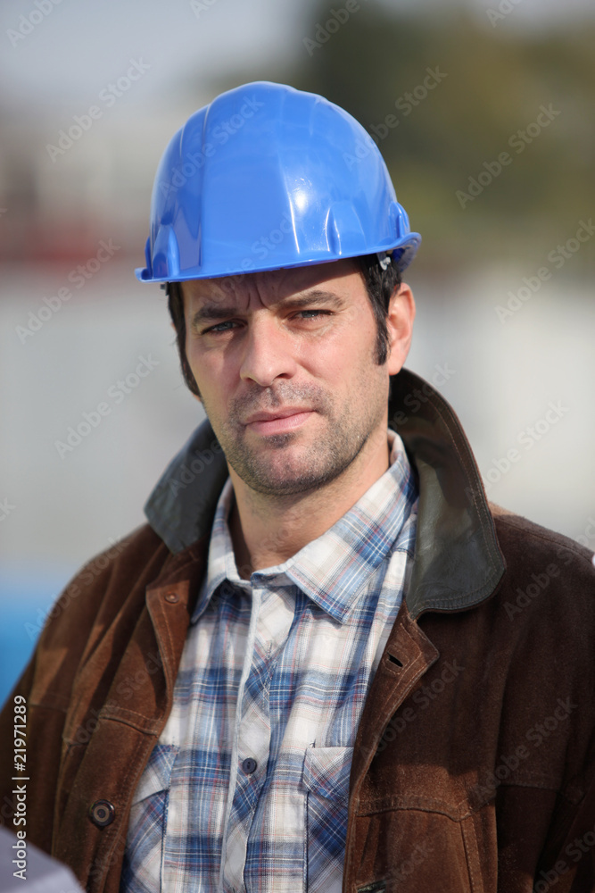 portrait d'un ouvrier avec casque de chantier bleu Photos | Adobe Stock