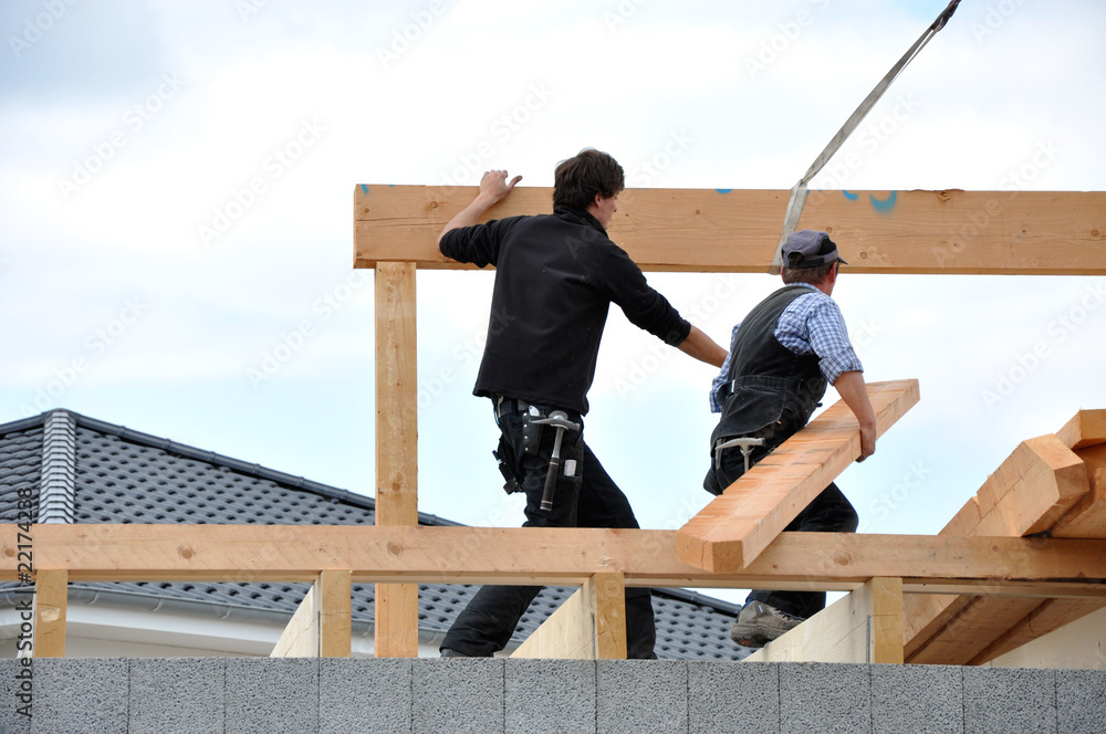 Zwei arbeitende Zimmermänner beim Dachbau, eine neue Konstruktion aus ...