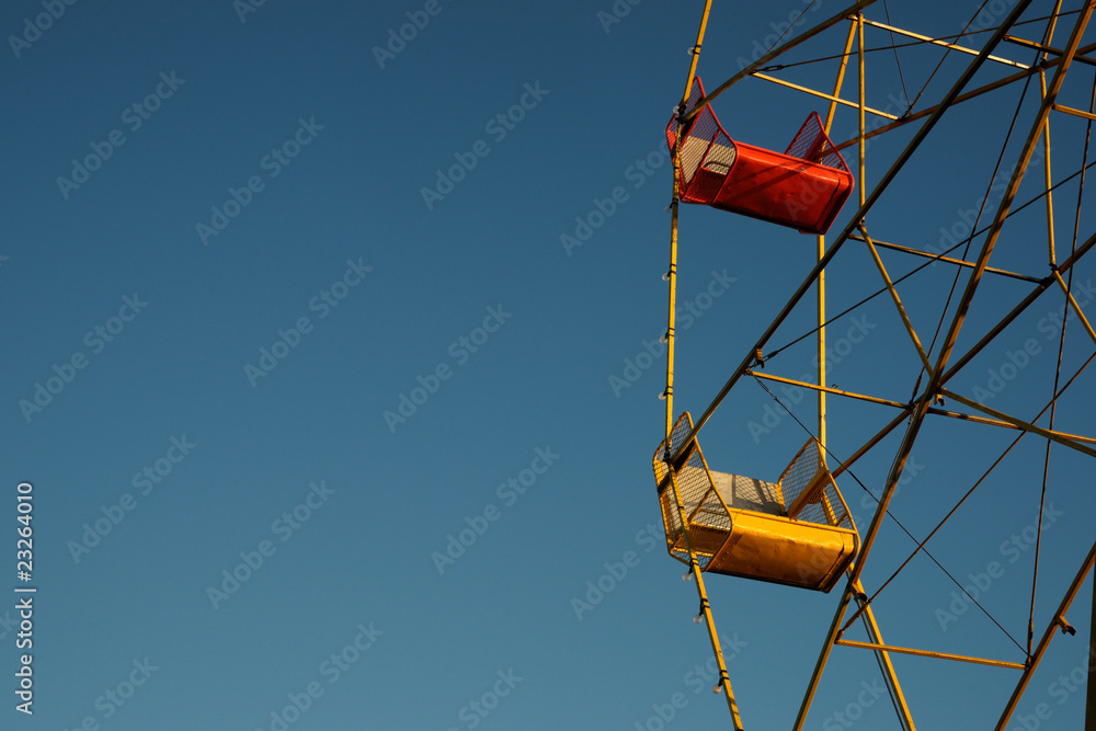 Old style ferris wheel seats against blue sky. Stock Photo | Adobe Stock