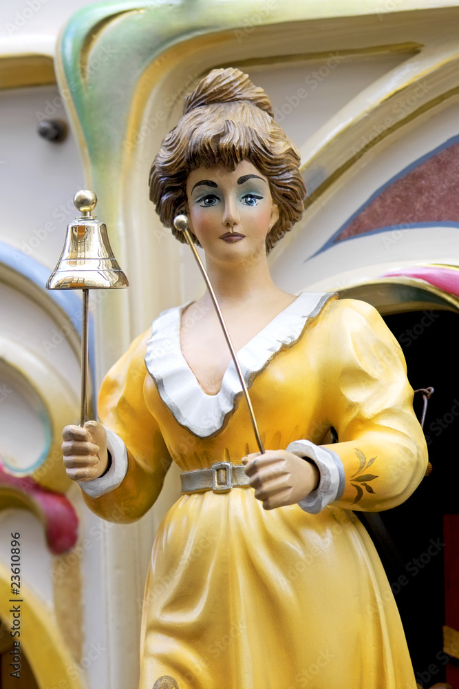 Female figure ringing a bell on a barrel organ Stock Photo | Adobe Stock