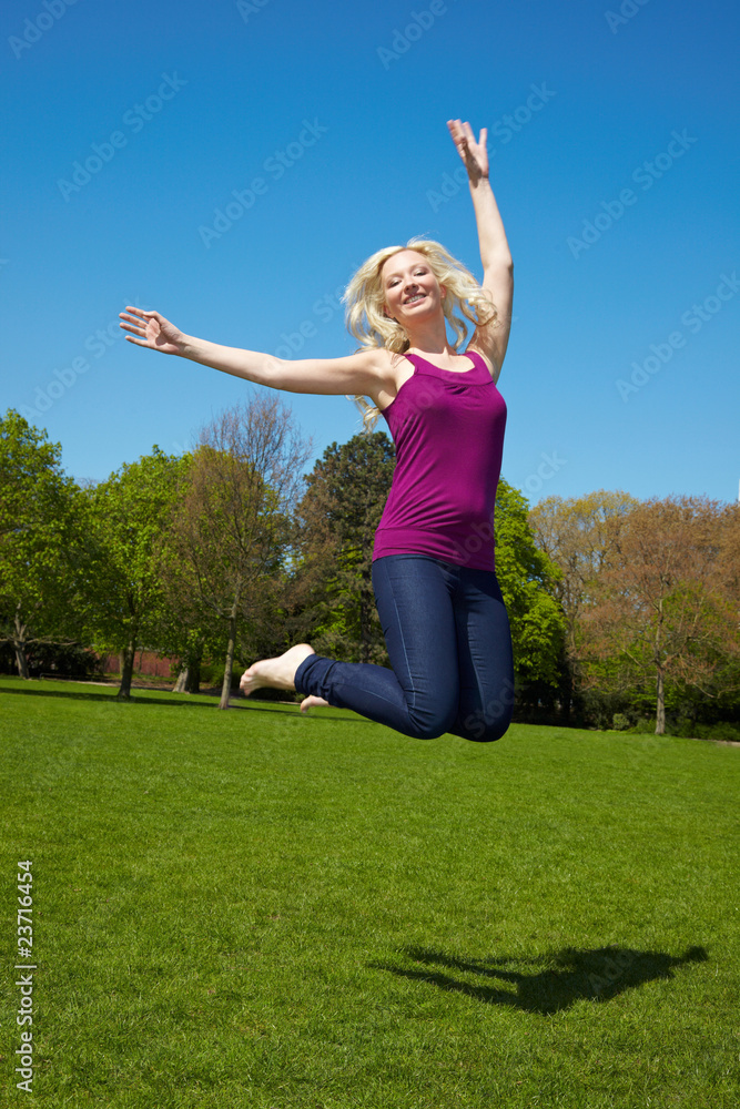 Blonde Frau springt im Park Stock Photo | Adobe Stock