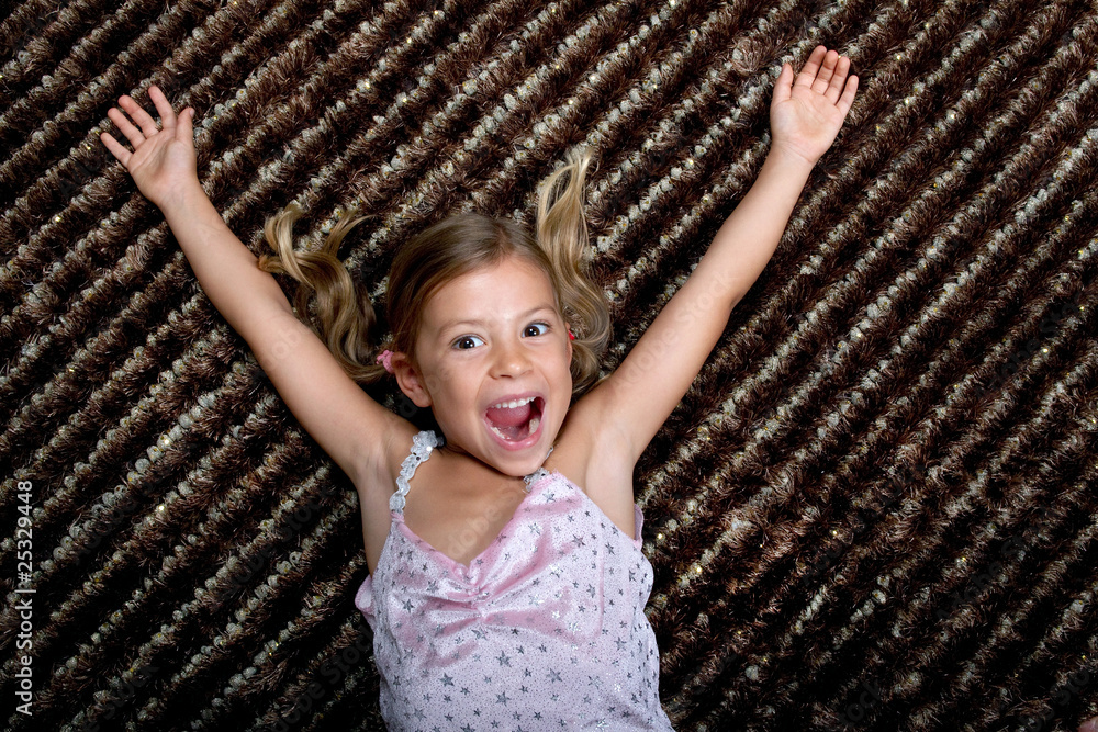 Little girl lying on a rug and cheering with delight Stock Photo ...