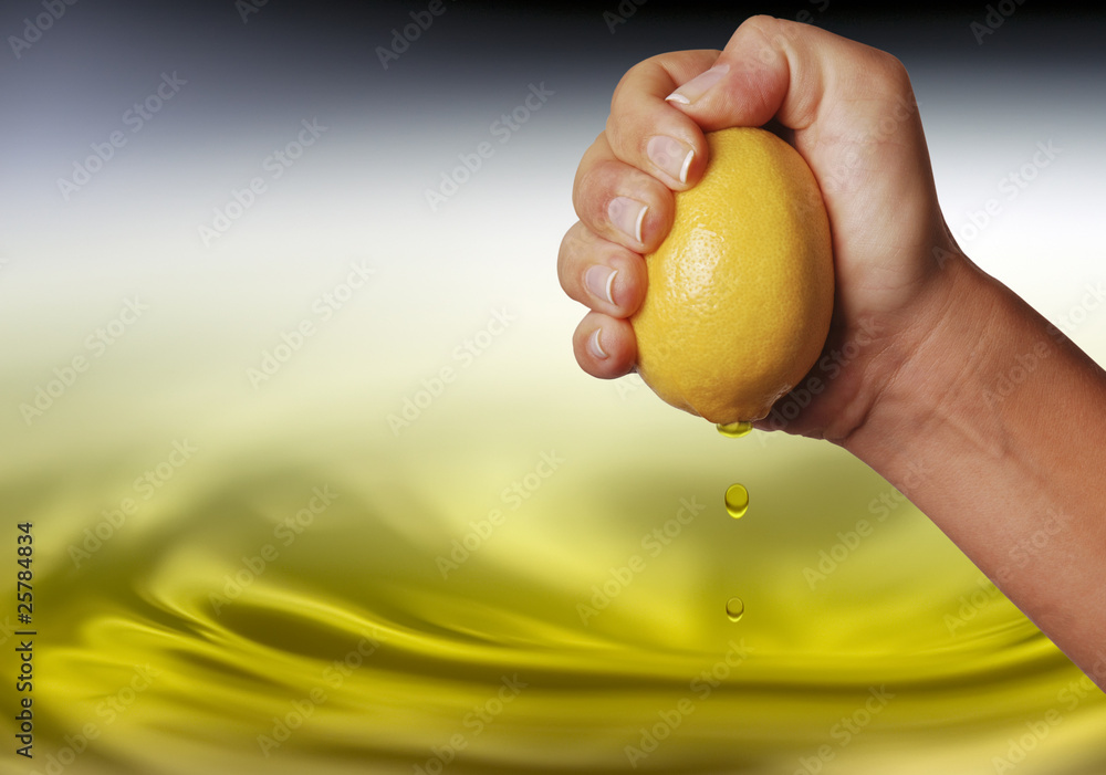 Hand squeezing fresh lemon with juice dripping of hand and lemon Stock ...